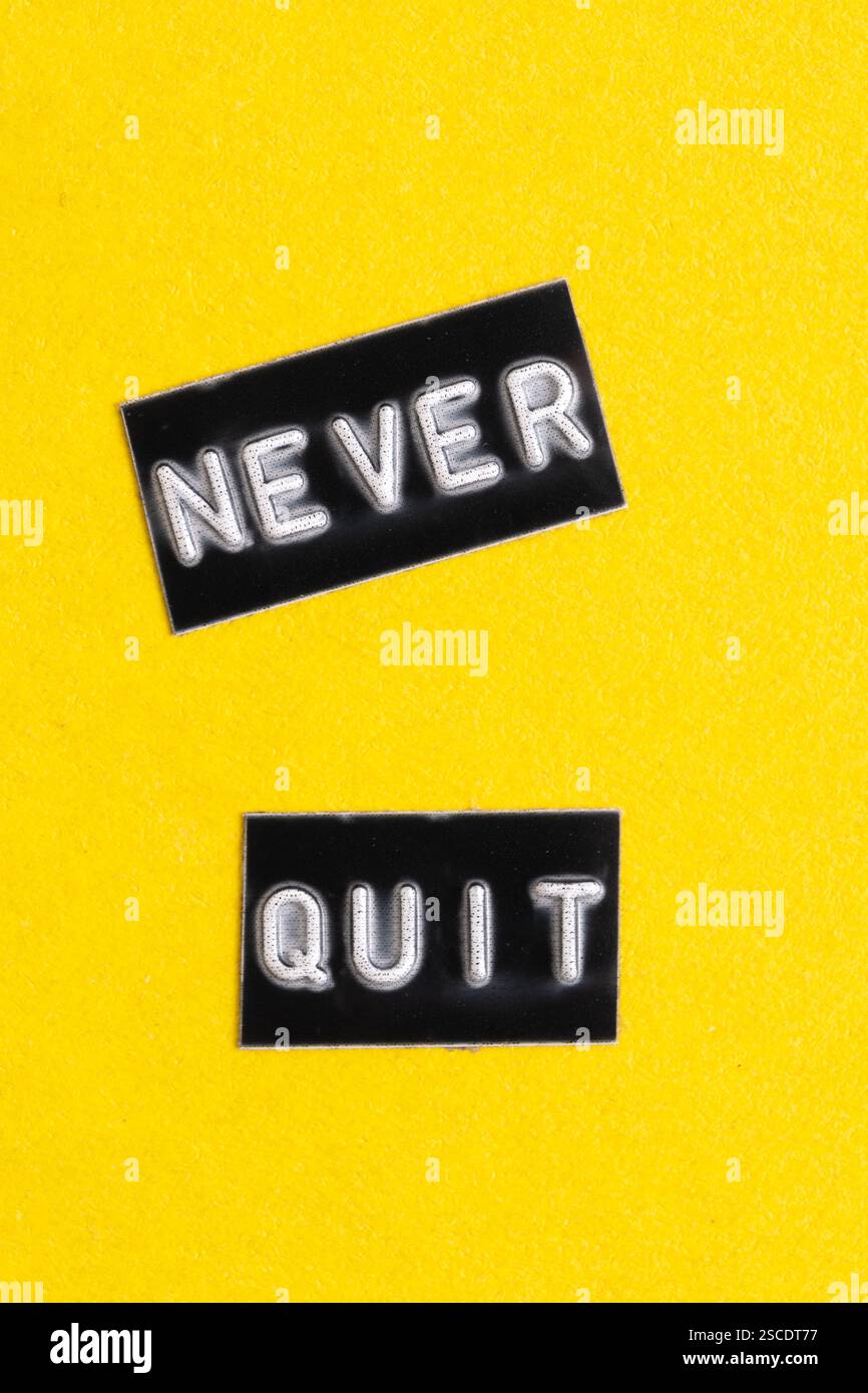 Closeup black letters on yellow background with words Never Quit Stock ...