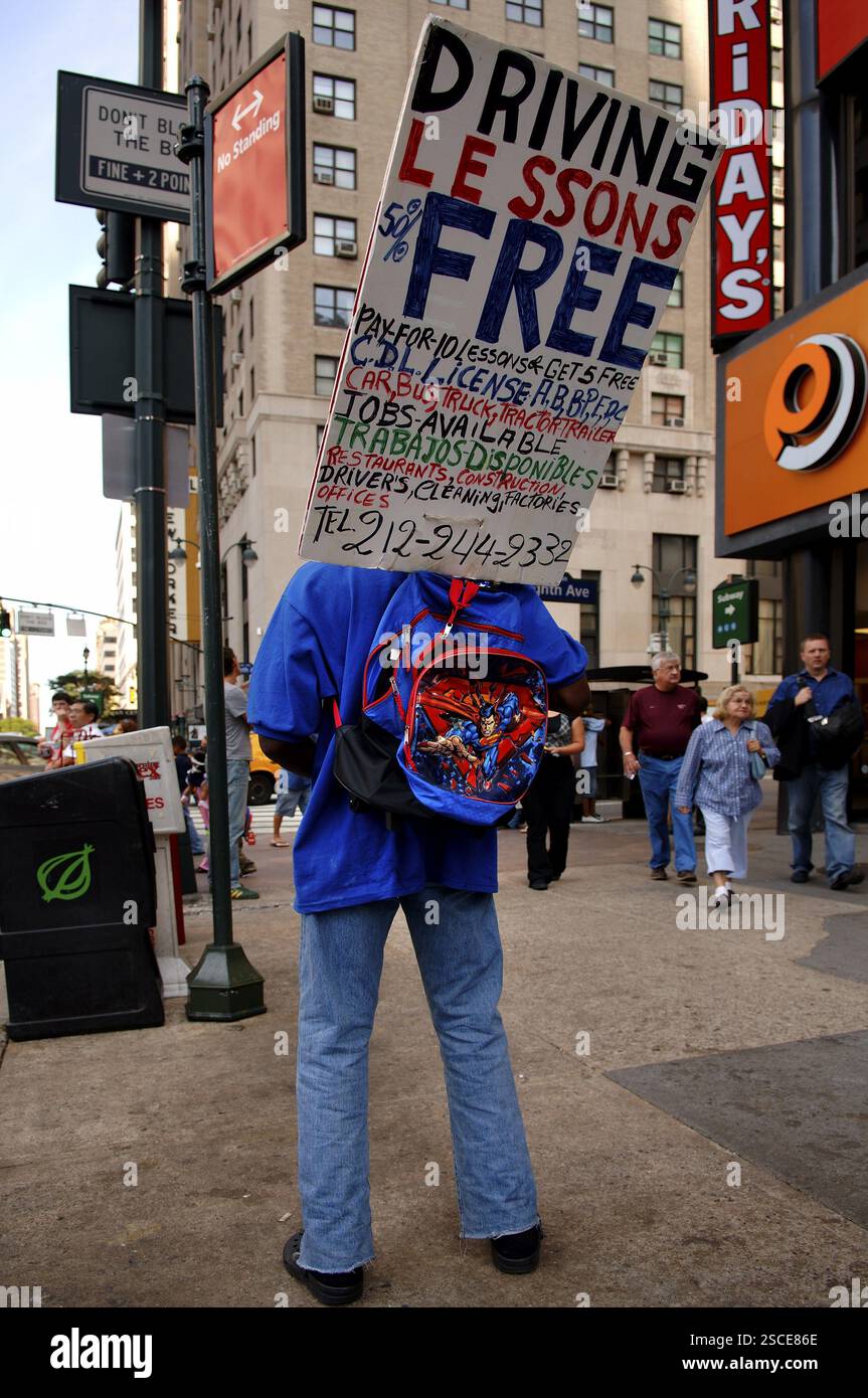 Man carrying an advertising sign for a driving school, New York City ...