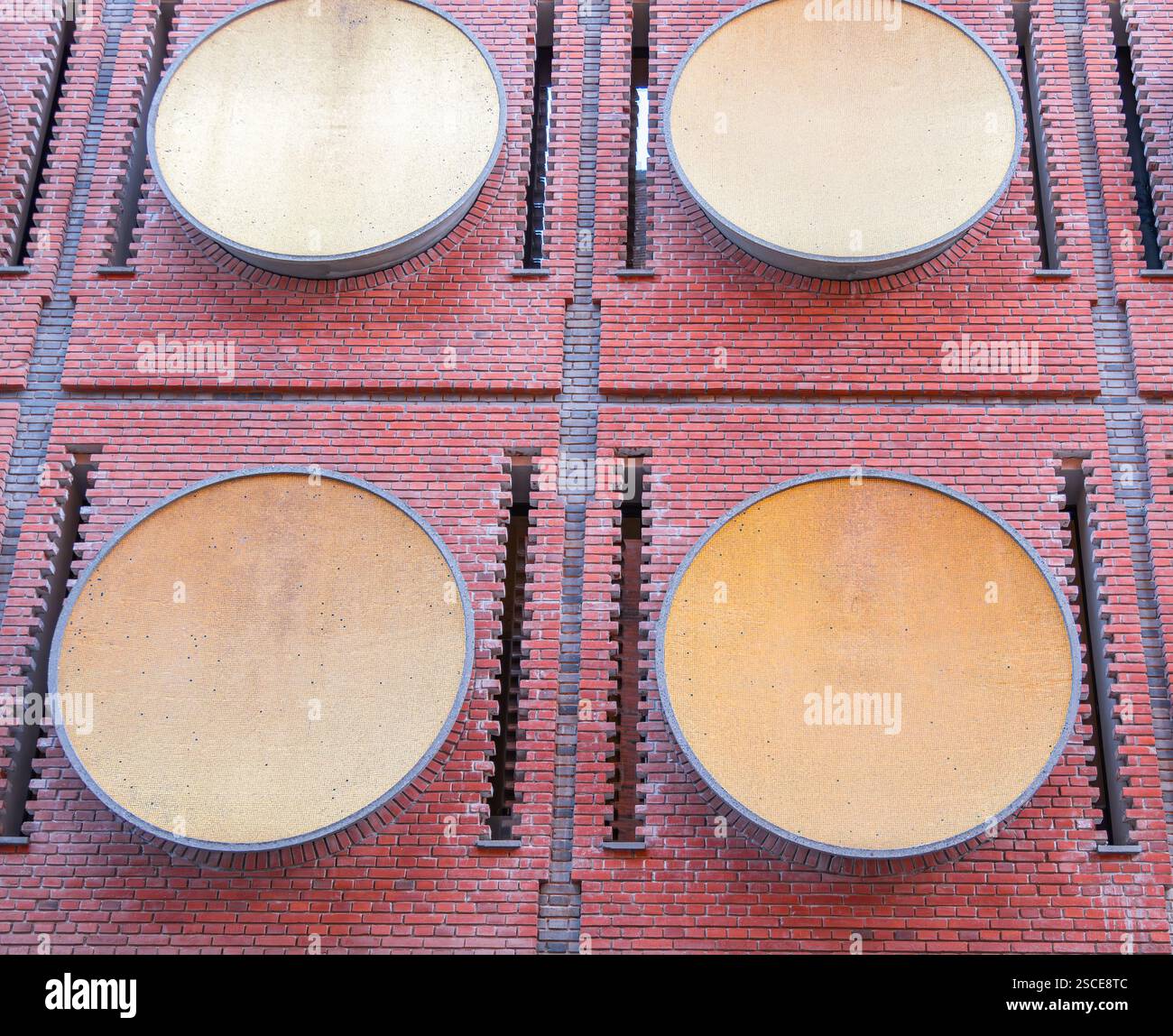 A modern brick wall featuring symmetrical oval structures for a ...