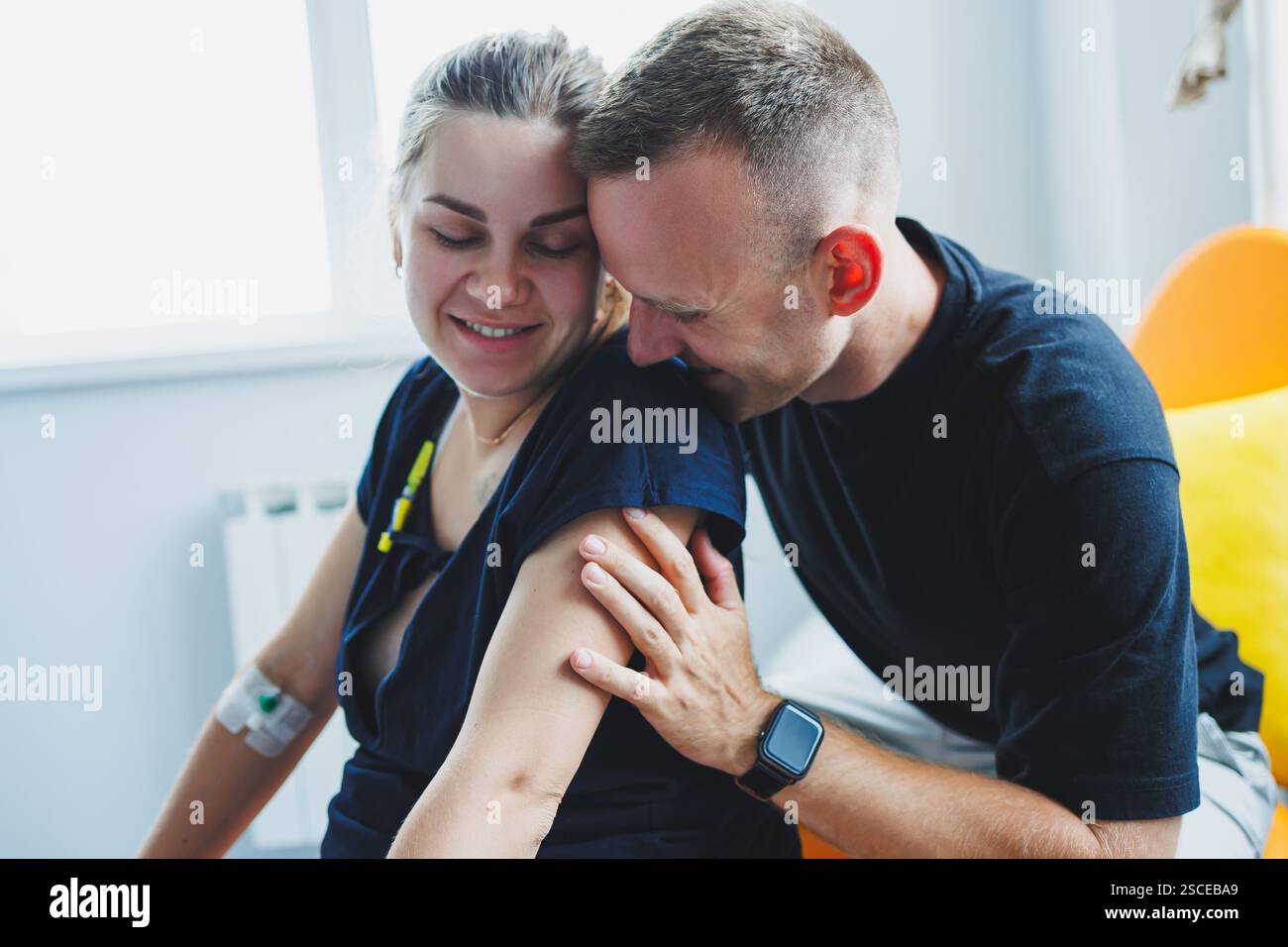 A husband hugs his wife who is giving birth. Giving birth together ...