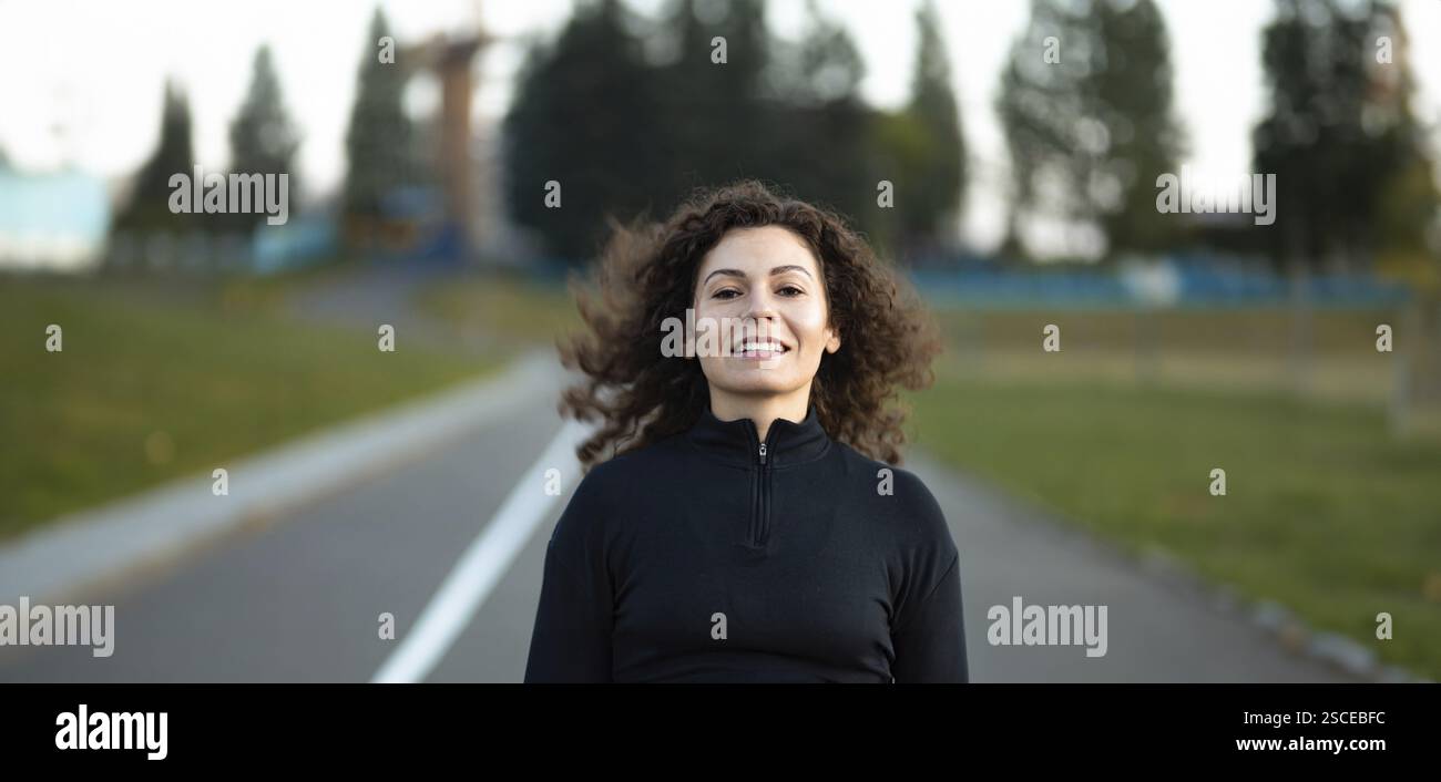 A woman happily running on a track in a pleasant outdoor setting Stock ...