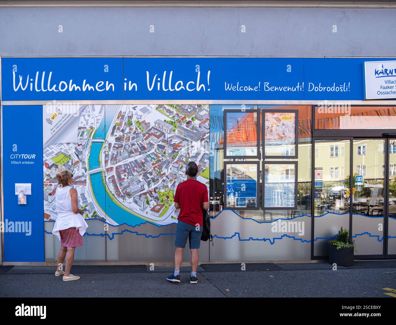 Villach, Austria - 23 July 2023: People looking at a city map on a wall ...