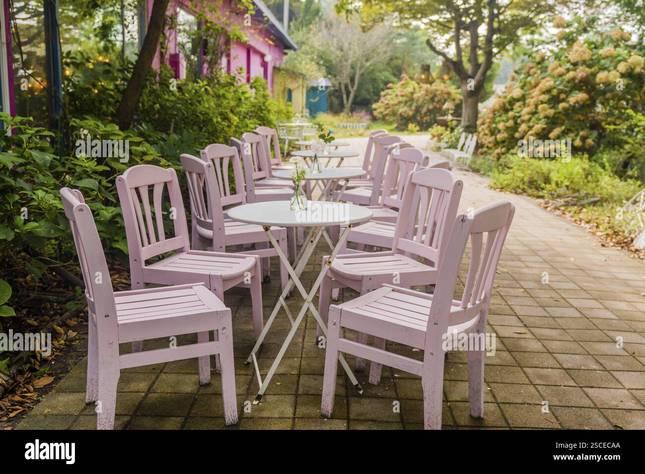 Outdoor seating arrangement with pink chairs and tables in a charming ...