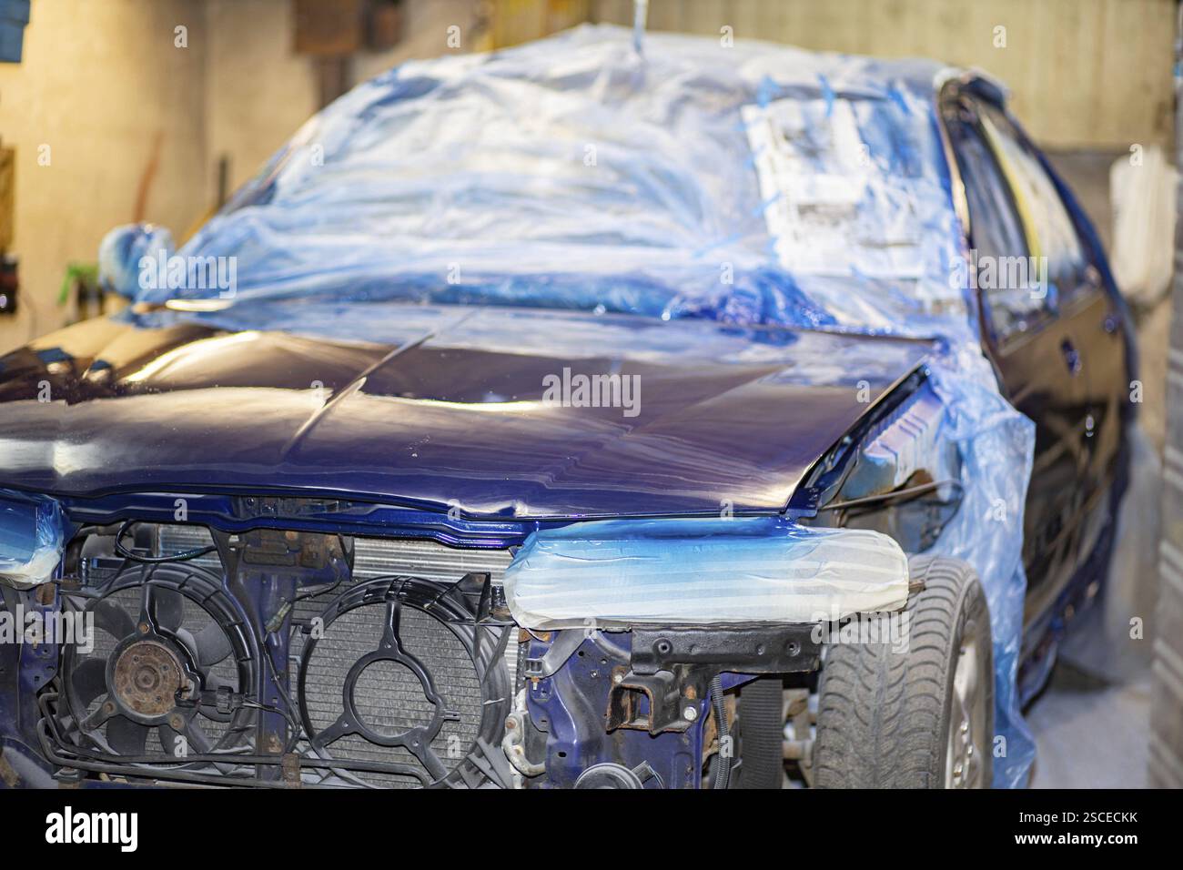 Disassembled blue car in a workshop, showing detailed paint work on the ...