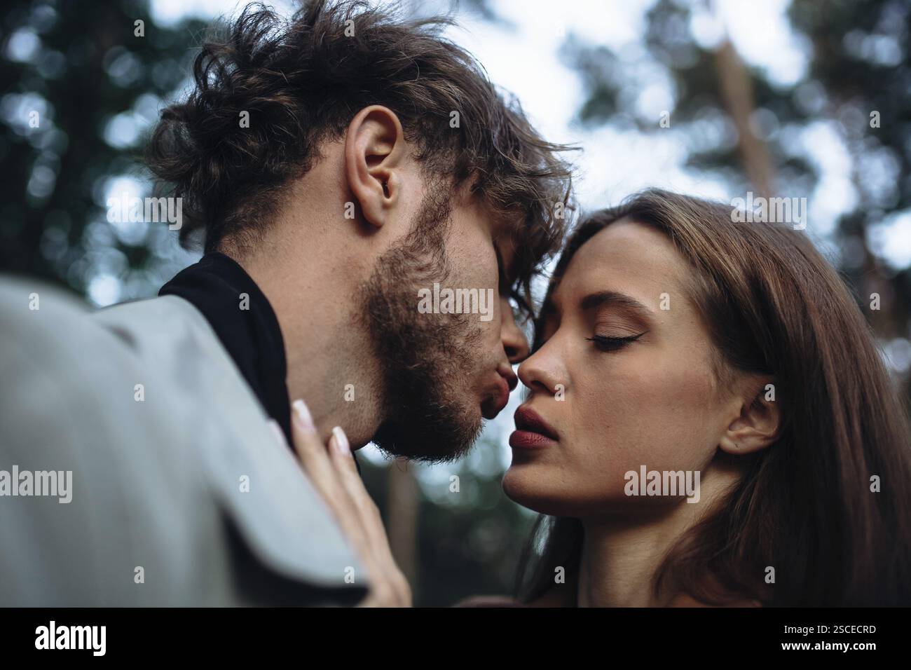 A close, intimate moment between a couple in a forest Stock Photo - Alamy