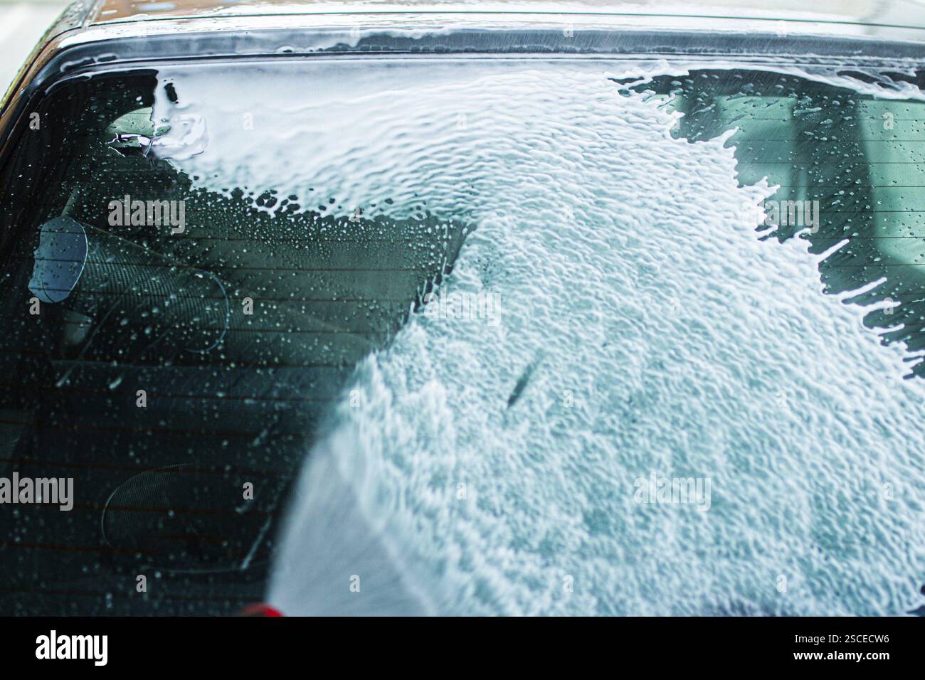Soap and water covering the rear window of a car during a wash Stock ...