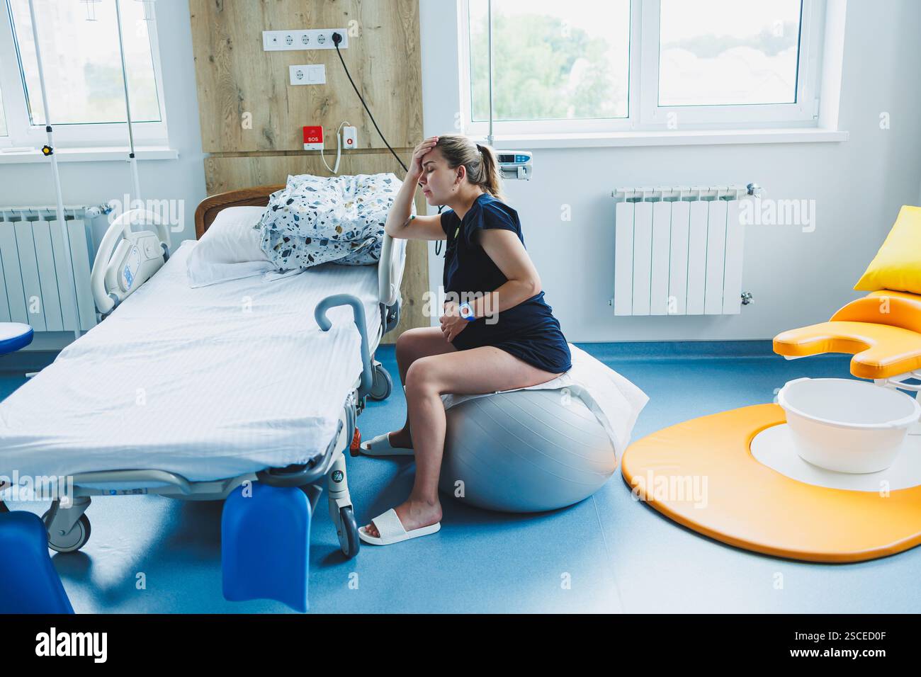 A woman in the delivery room feels contractions and severe pain in her ...