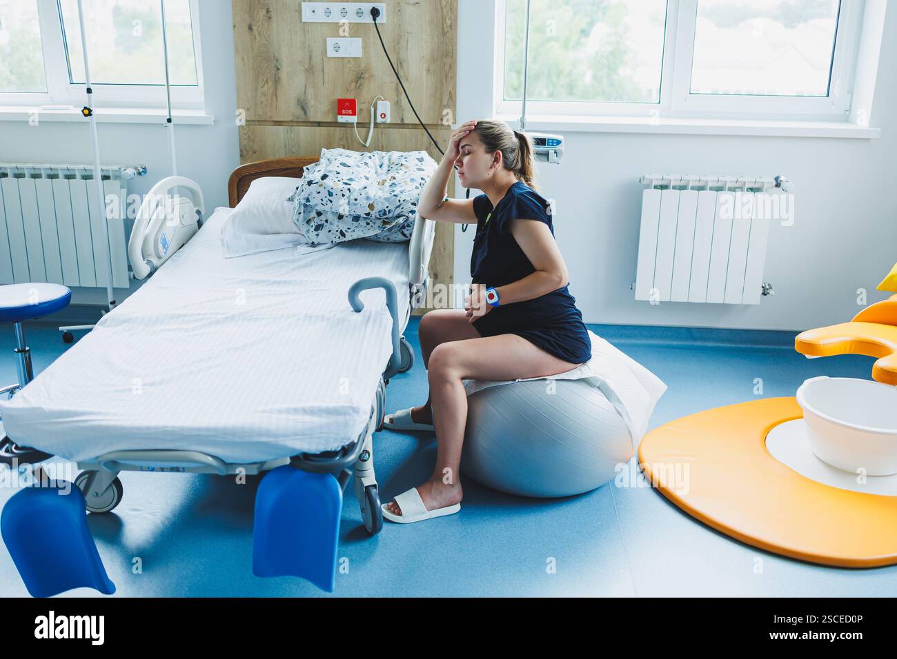 A woman in the delivery room feels contractions and severe pain in her ...