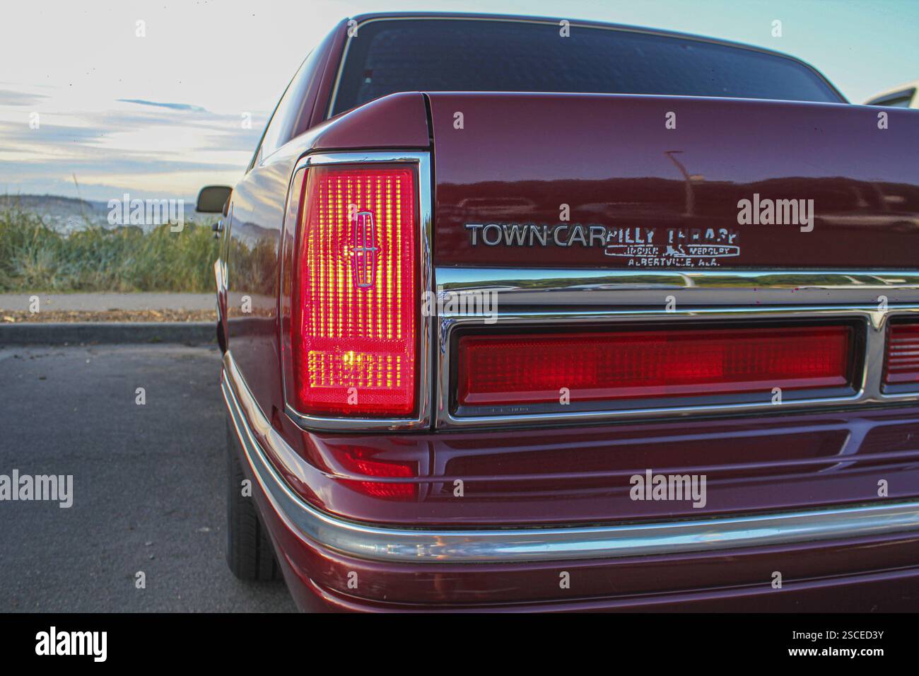 Close-up of a classic car's tail light with a maroon exterior in a ...