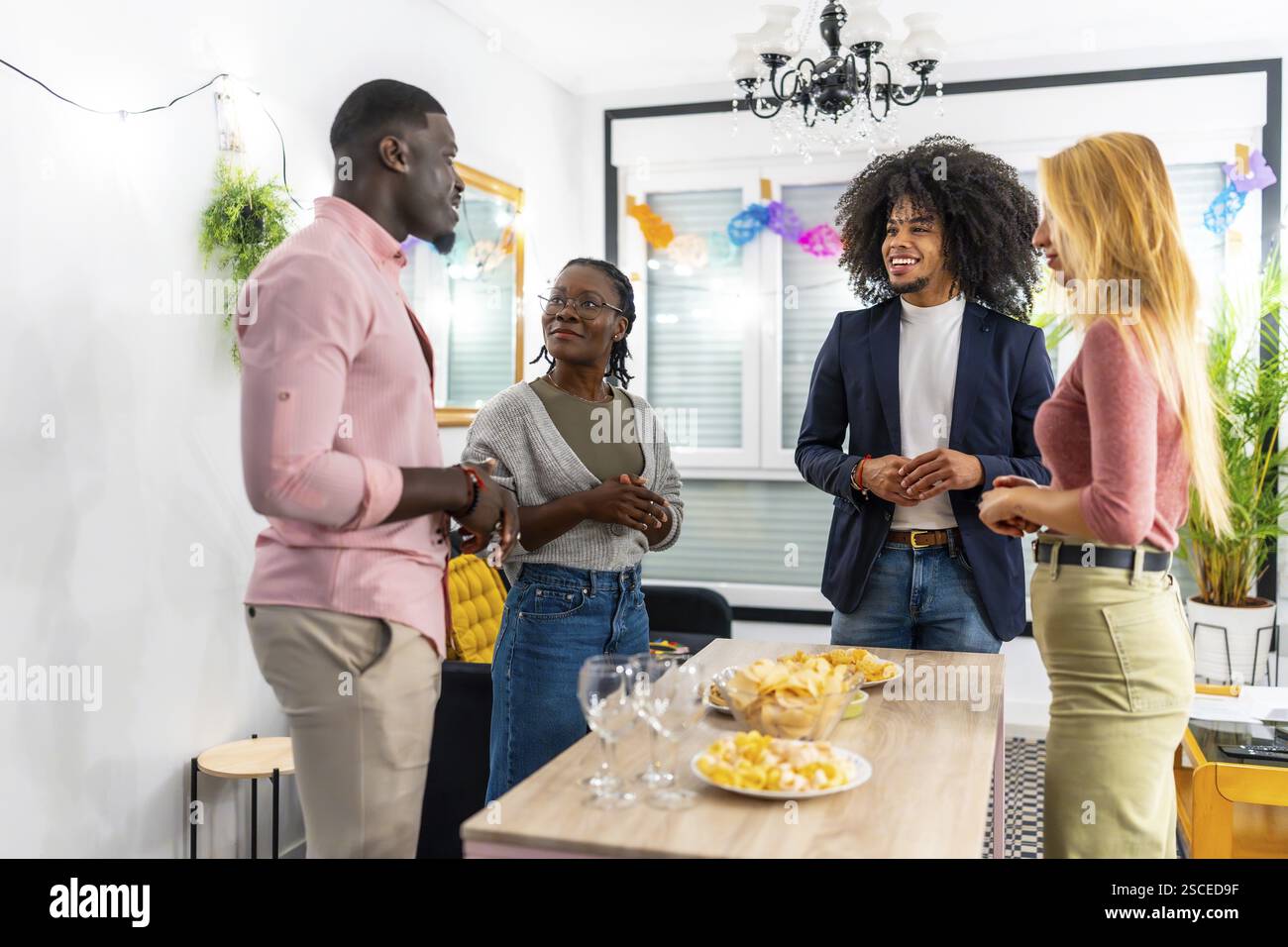 Multicultural males and females friends talking around dining table ...