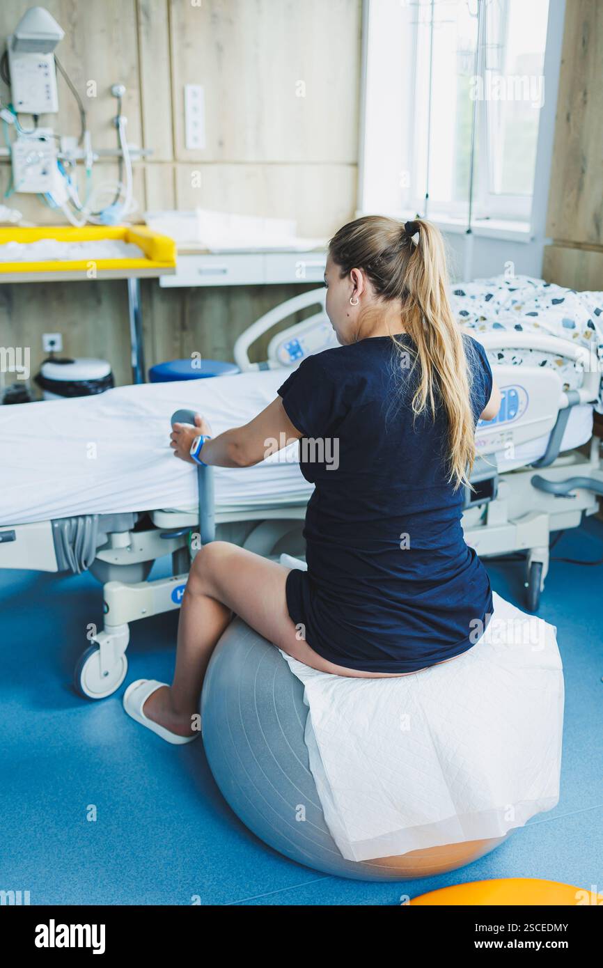A woman in the delivery room feels contractions and severe pain in her ...