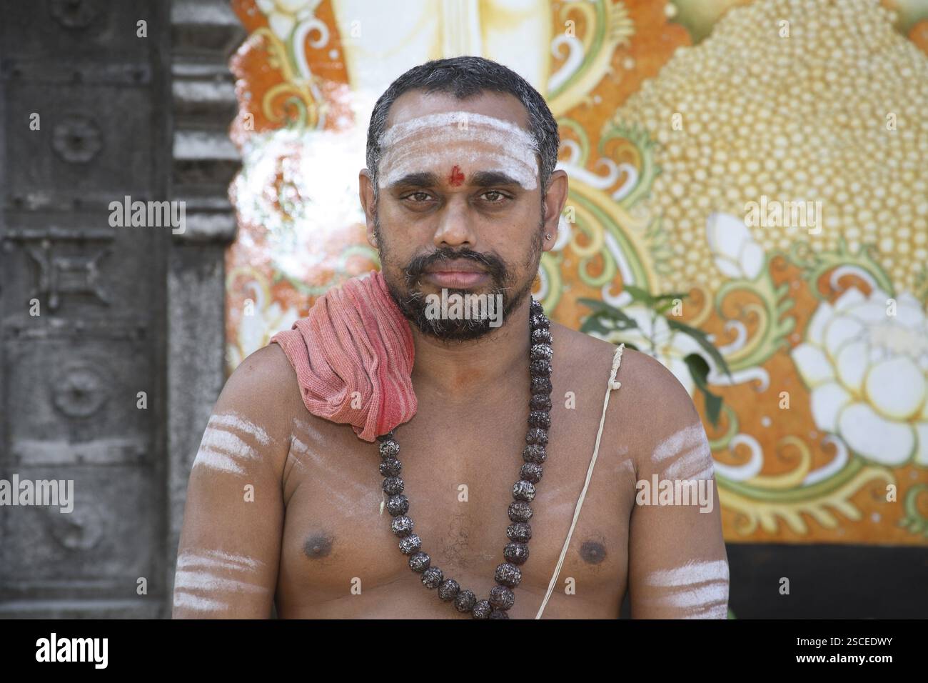 Religious preacher wearing rudraksha mala applying holy ash or bhasma ...