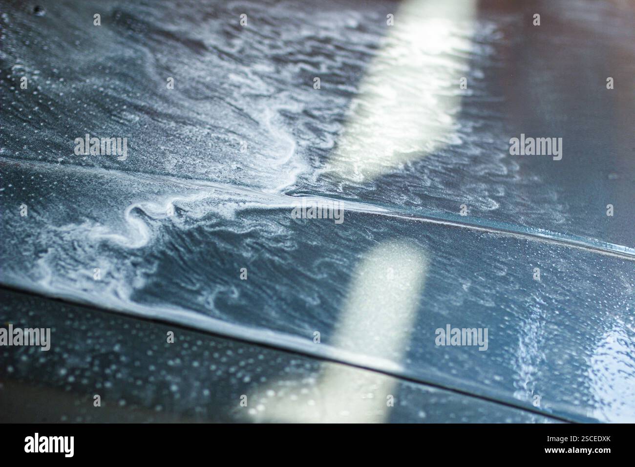 Detailed view of car hood with soap and water textures during wash ...