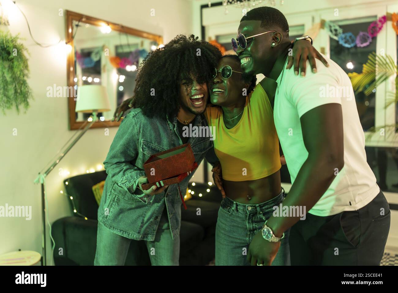 African young woman hugs her friends gratefully for a birthday gift at ...