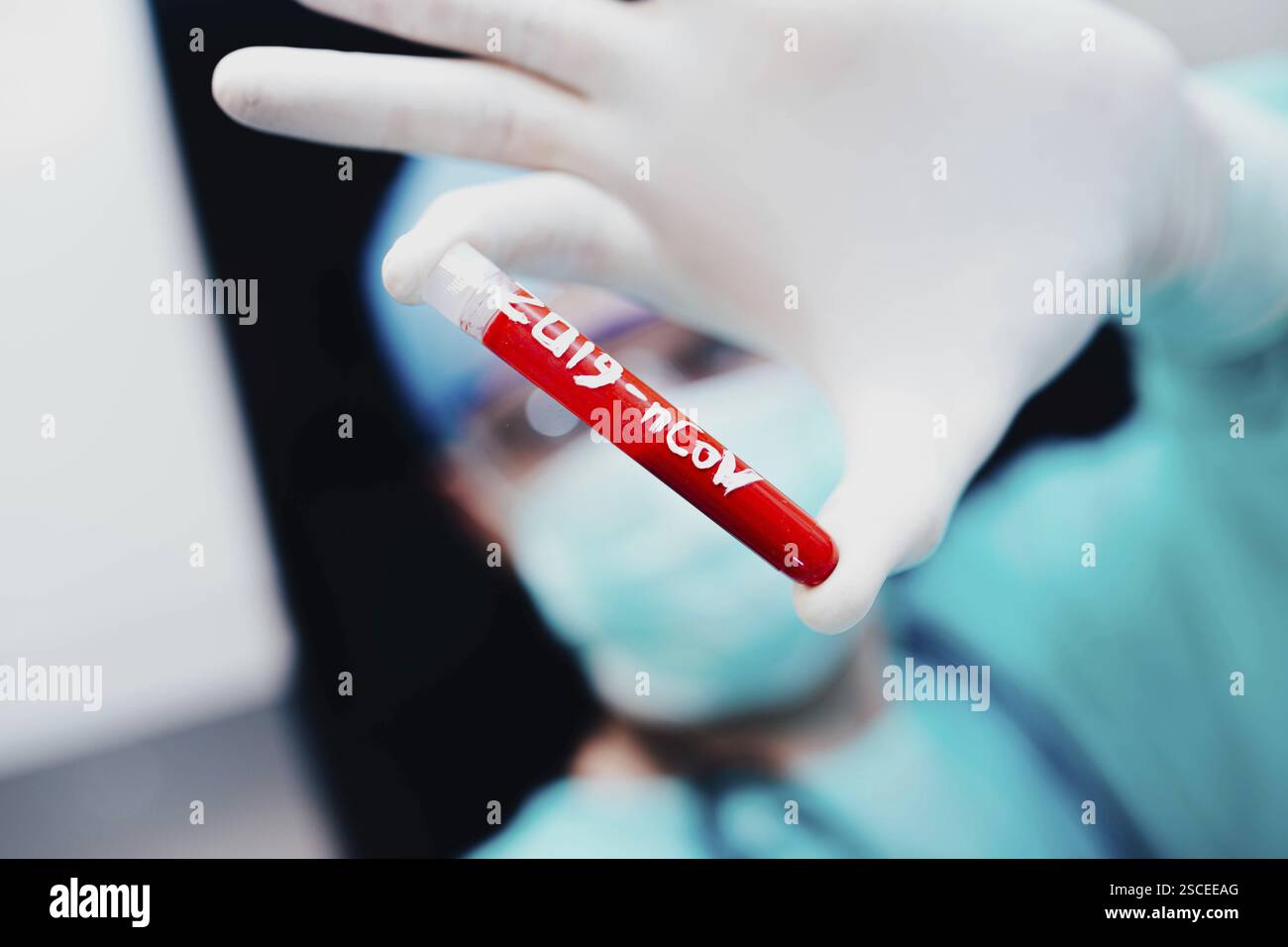Medical professional showing a test tube labeled 2019-nCoV in gloved ...