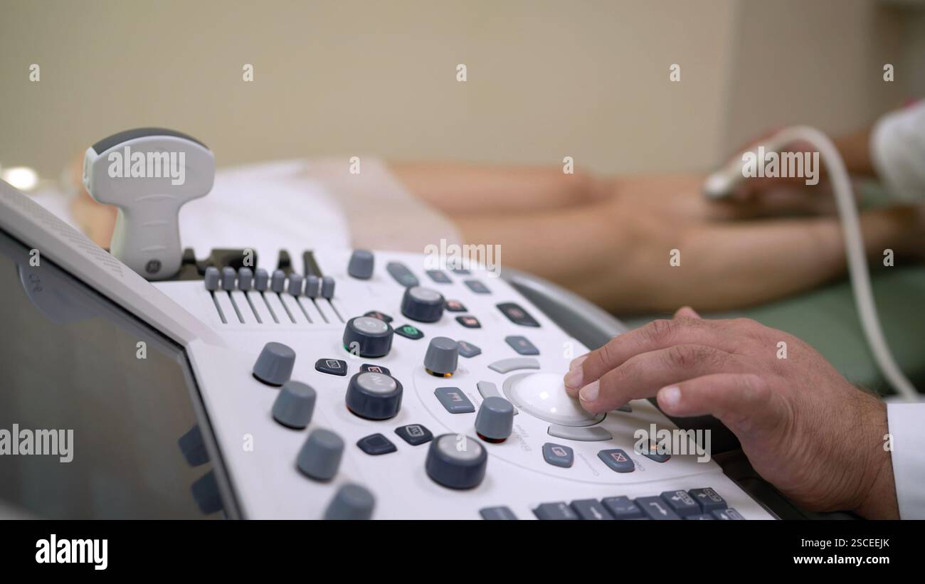 Doctor operating ultrasound scanner, conducting diagnostic procedure on ...