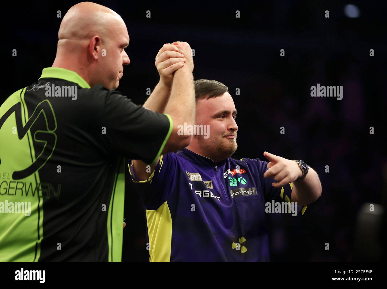 Luke Littler (right) and Michael van Gerwen embrace after their match ...