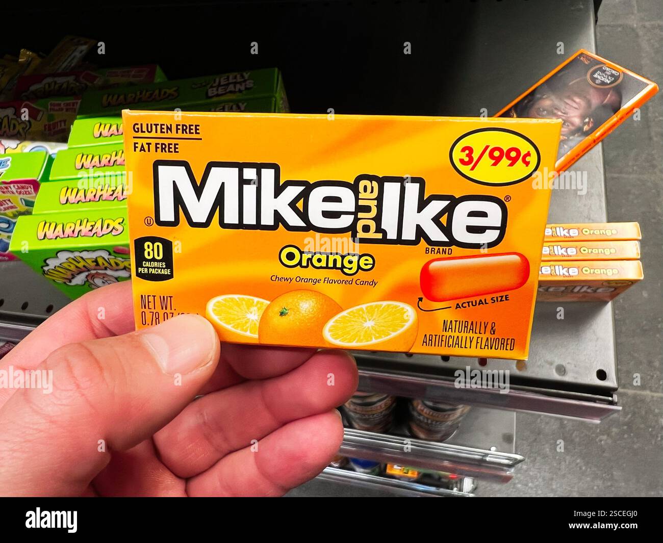 Kyiv, Ukraine - February 05, 2025: Hand holding an orange Mike and Ike ...