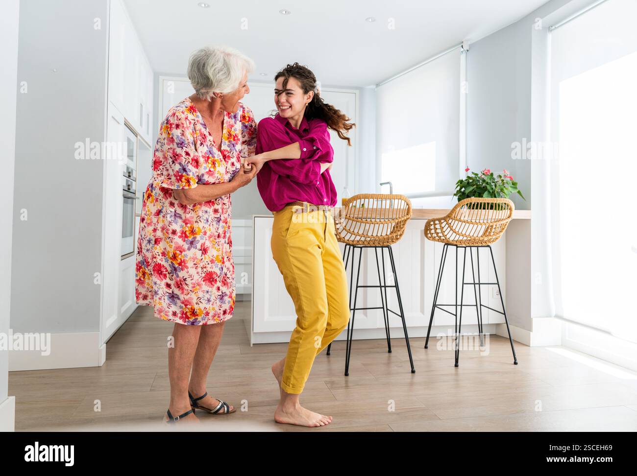 Beautiful grandmother and granddaughter together at home having fun ...