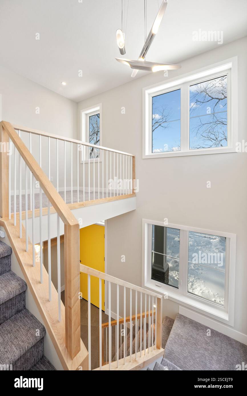 A staircase with a yellow door leading to a second floor. The staircase ...