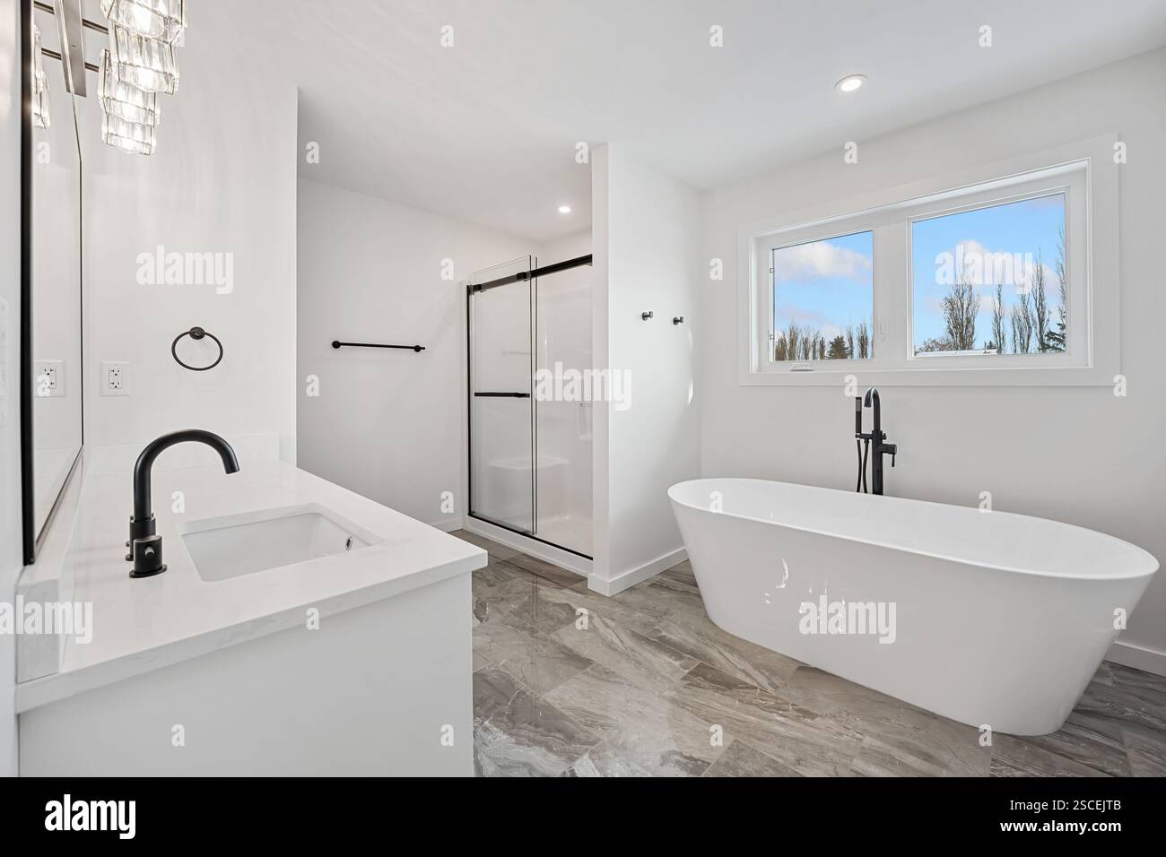 A bathroom with a white tub and sink. The bathroom is clean and well ...