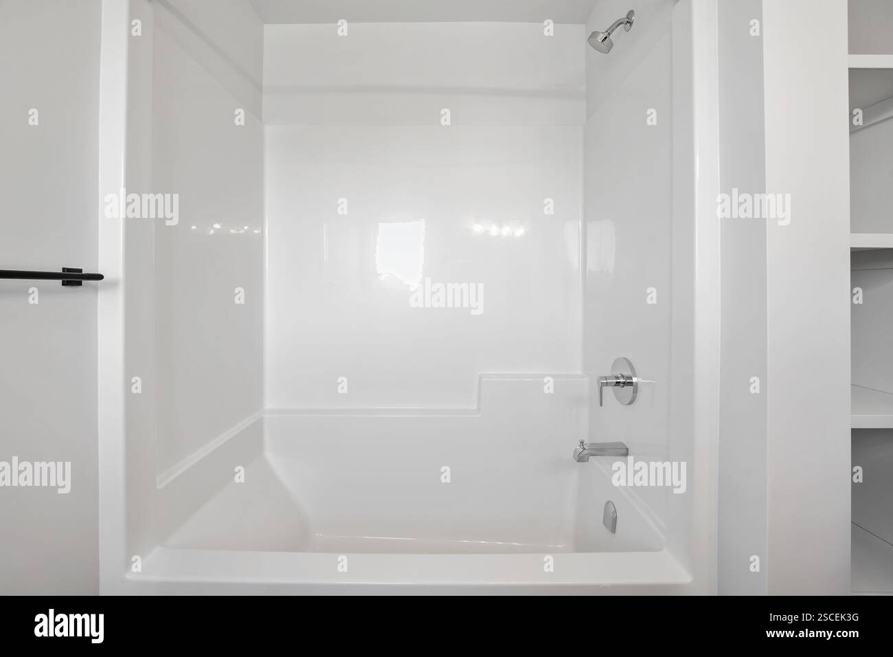A white bathroom with a white bathtub and a white shower. The shower is ...