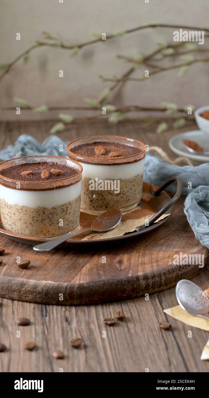 Two delicious tiramisu overnight oats in clear glass containers, layered with creamy oats ...
