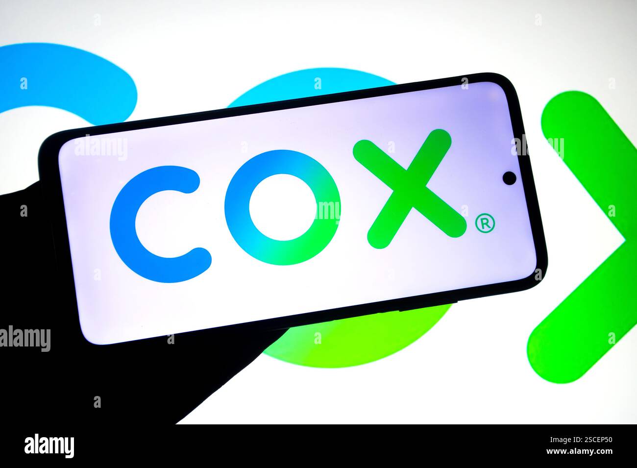 In this photo illustration, a COX logo is seen displayed on a ...