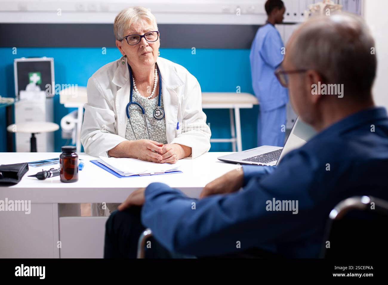 Selective focus on elderly female doctor listening to health concerns ...