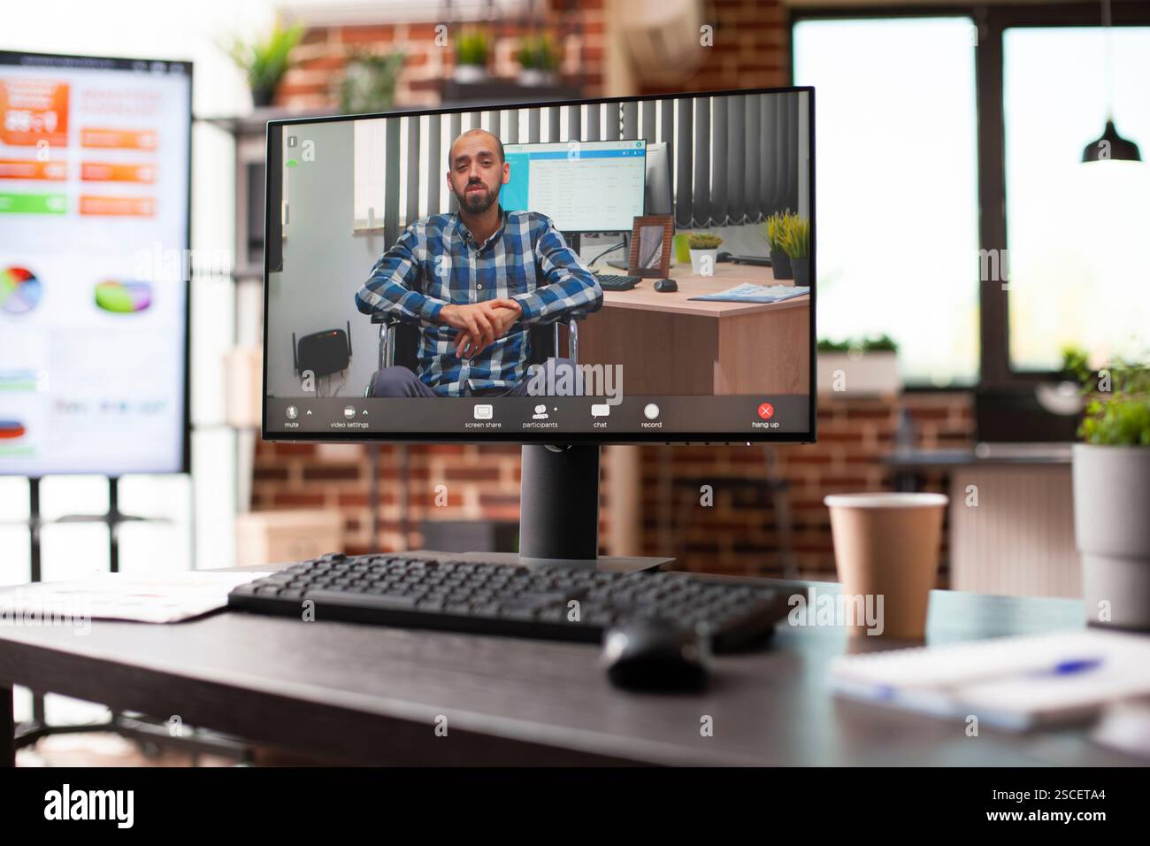 Vacant table with desktop screen displaying online session with ...