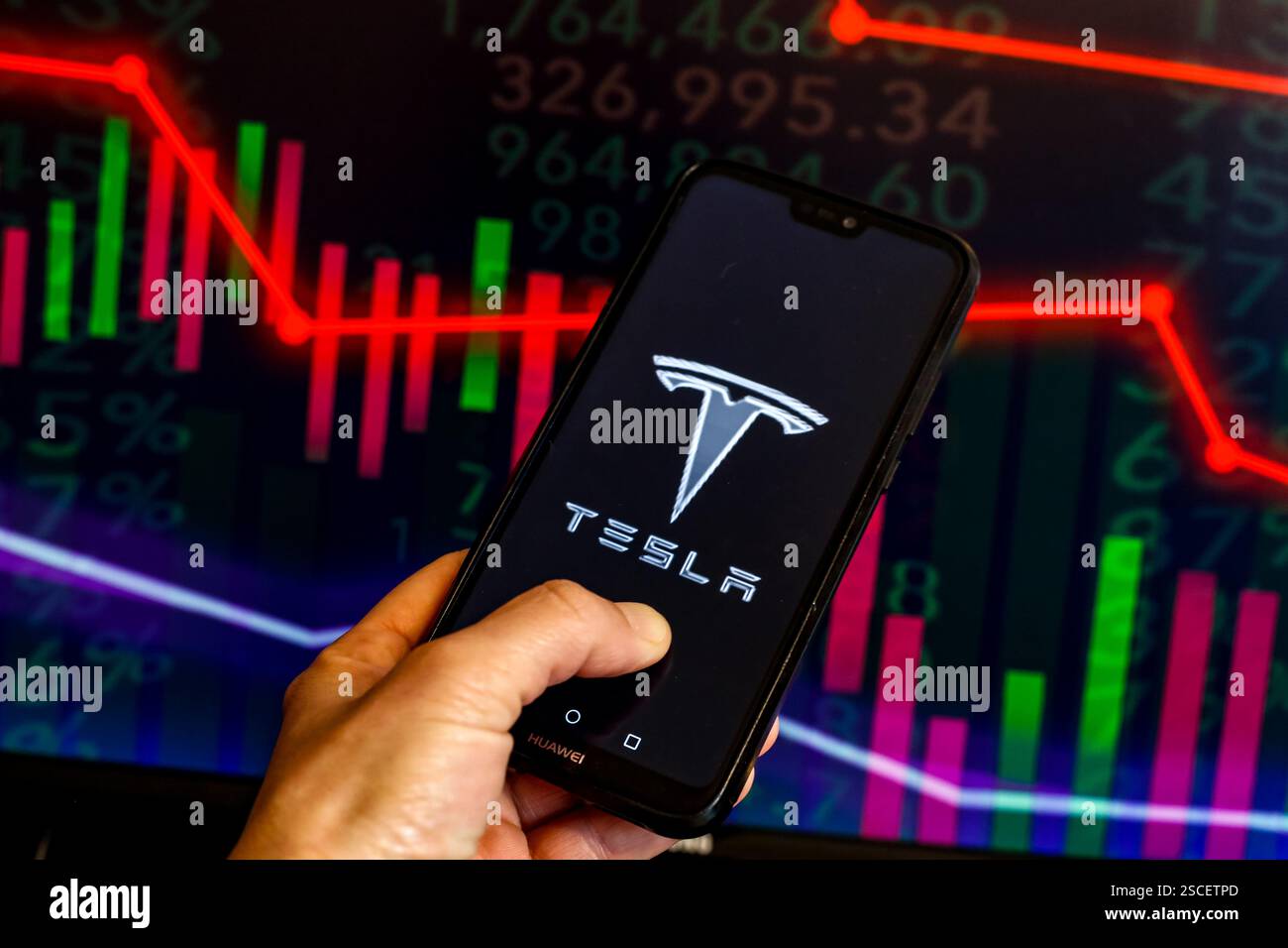 In this photo illustration, the Tesla logo is seen displayed on a ...