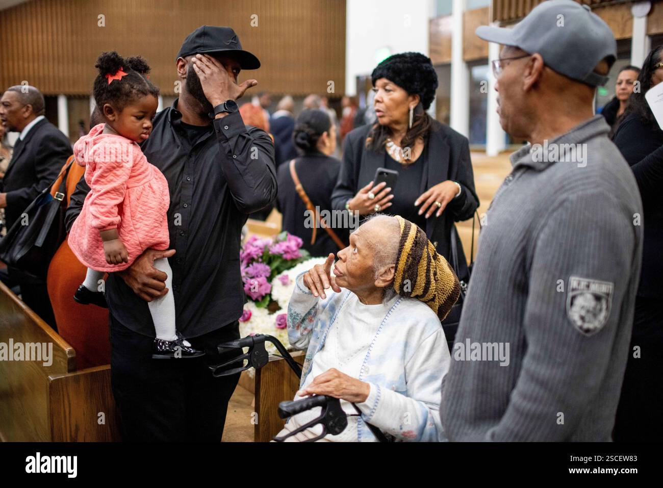 Zaire Calvin, left, who lost his sister in the Eaton fire, wipes his ...