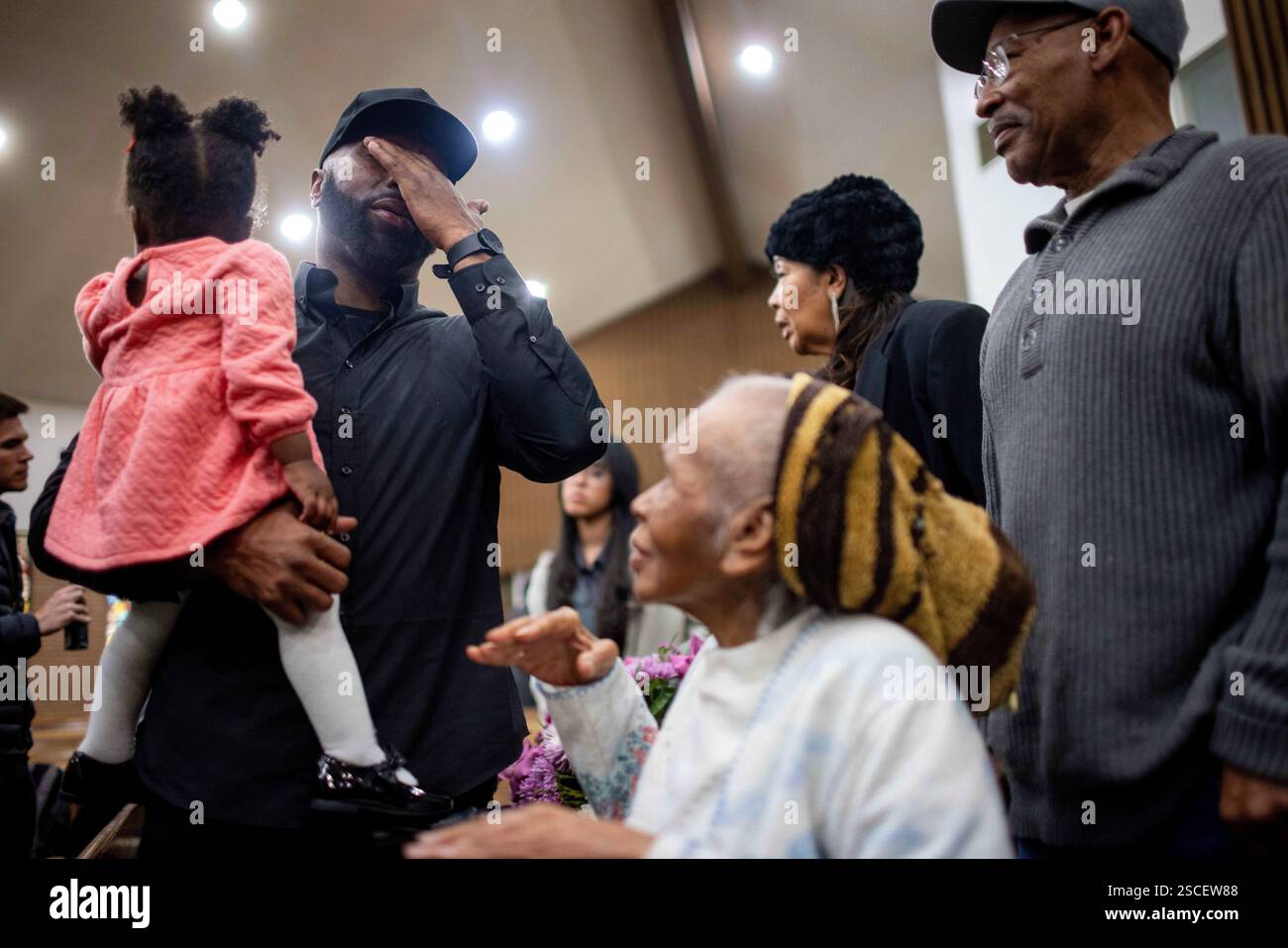 Zaire Calvin, left, who lost his sister in the Eaton fire, wipes his ...