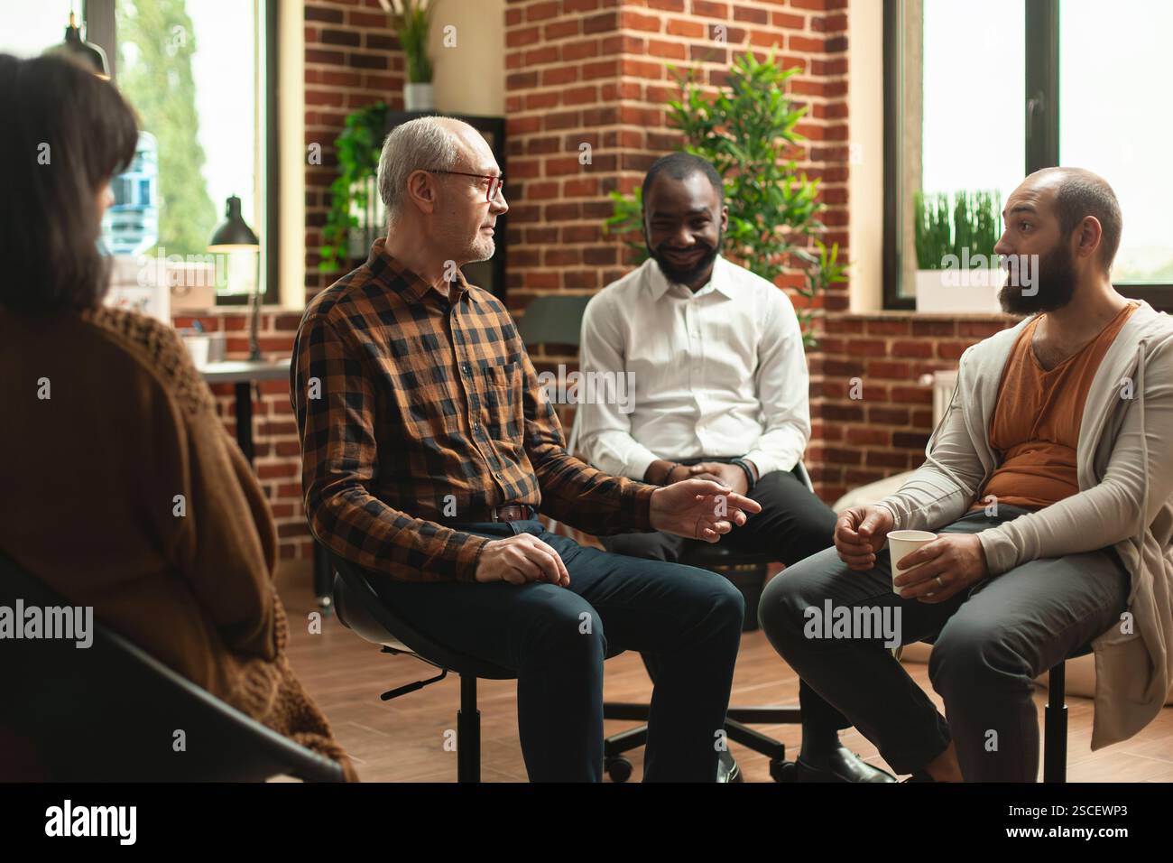 Caucasian men having conversation as black man smiles at camera in ...