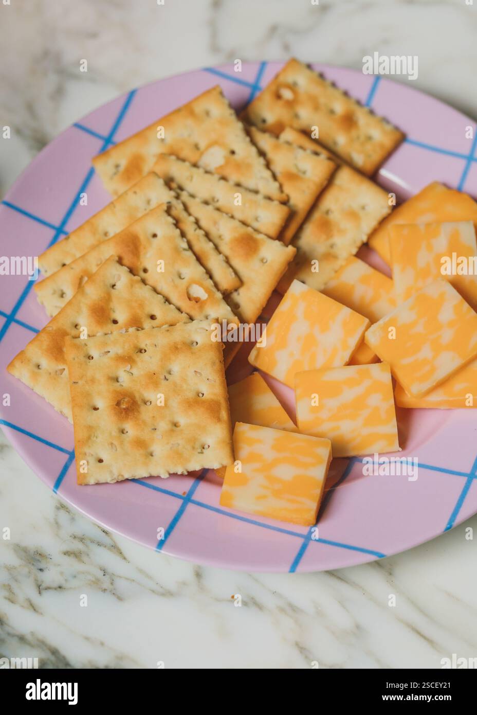 Square rosemary saltine crackers and square pieces of colby jack cheese ...