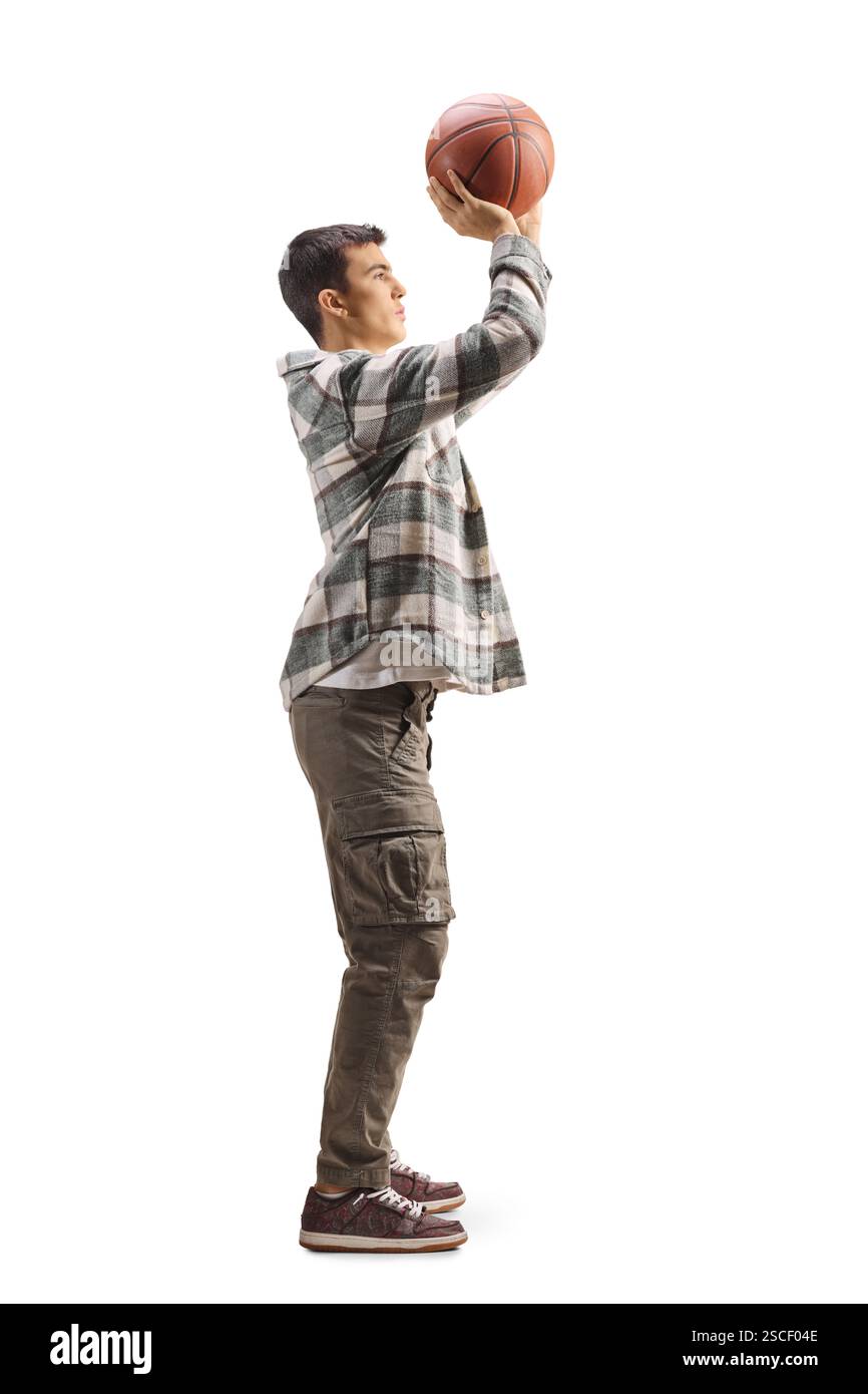 Full length profile shot of a teenage guy shooting a basketball ...