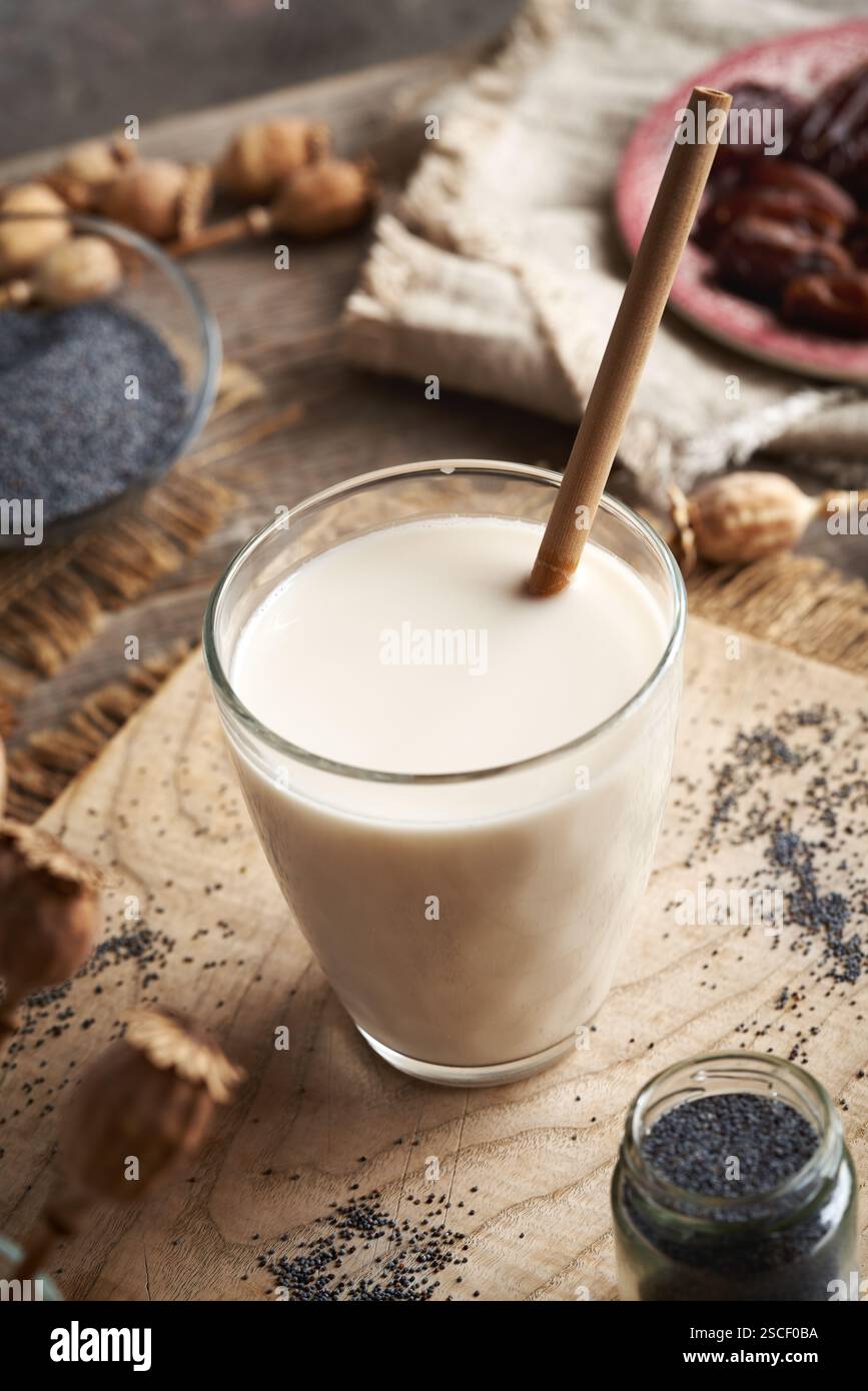 Vegan poppy seed milk in a glass cup with ecological bamboo straw. Zero ...