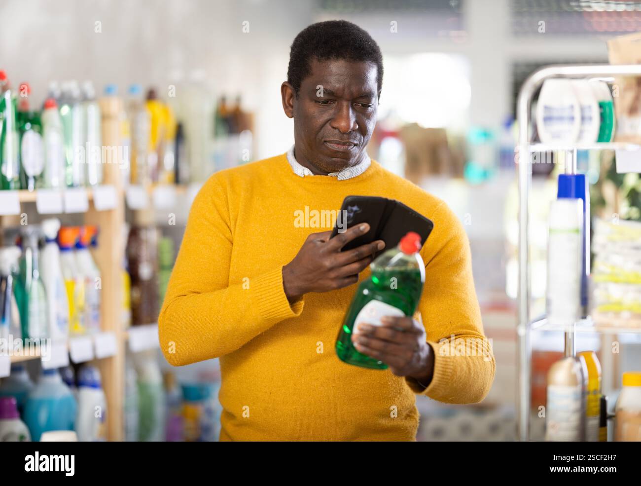 Male shopper checks a QR code on a dishwashing sponge label in ...