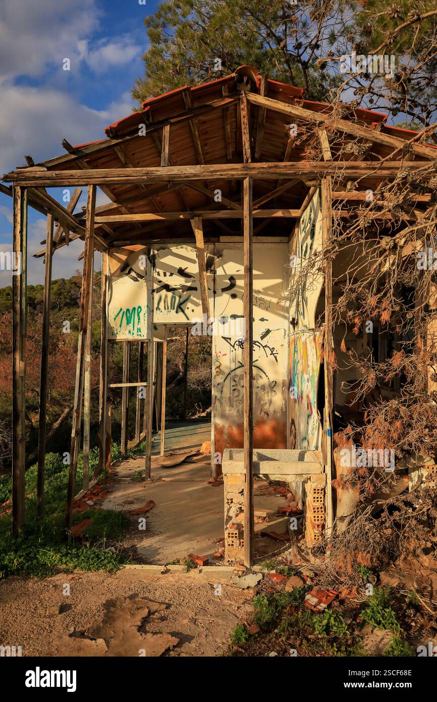 Ruined wooden structure with a damaged roof, graffitied walls, and ...