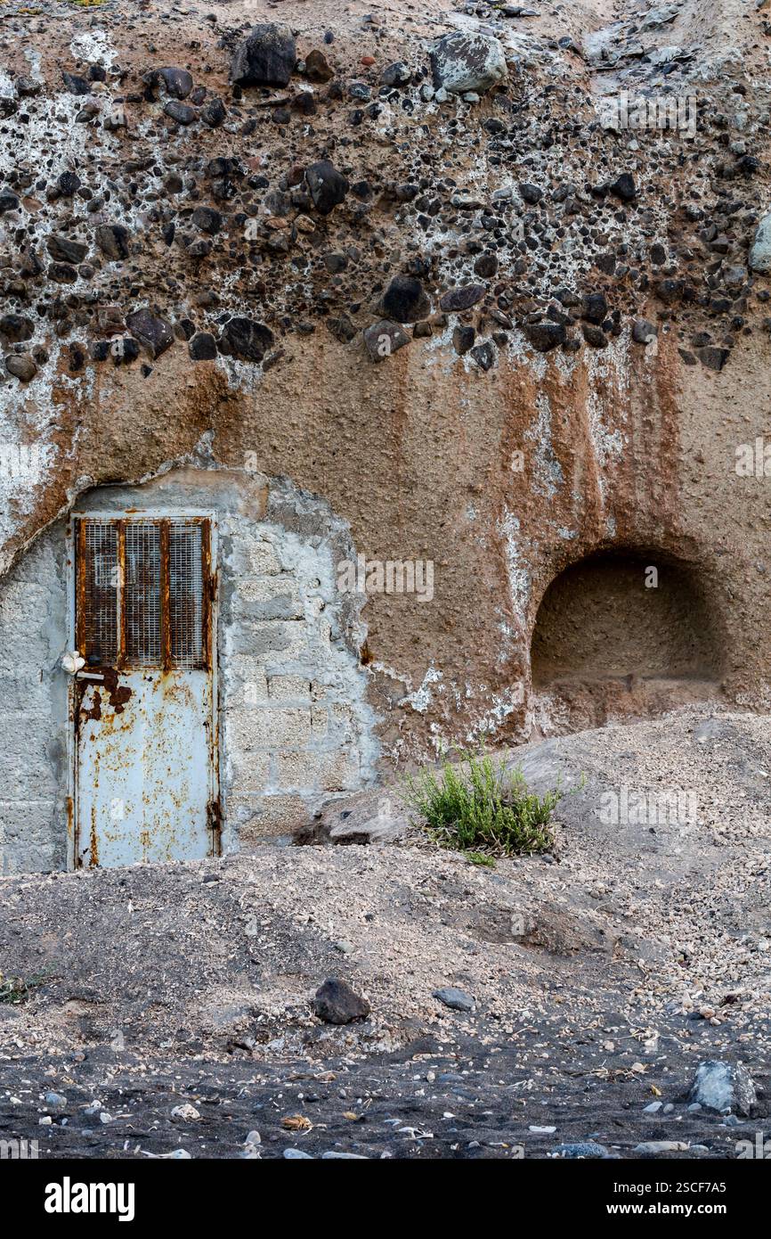 cave houses integrated into a natural rock formation, in Santorini ...