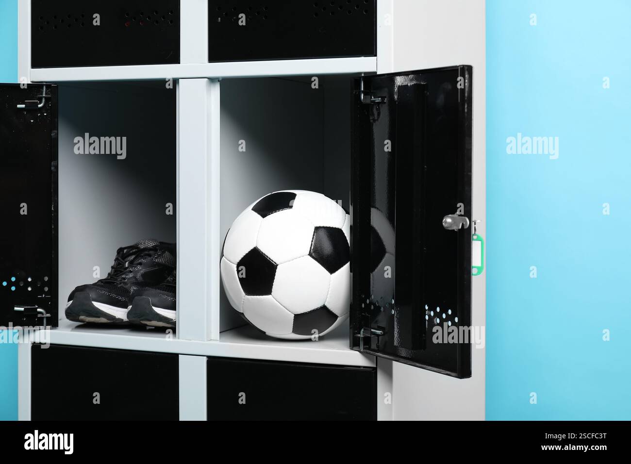 Open lockers with soccer ball and sneakers on light blue background ...