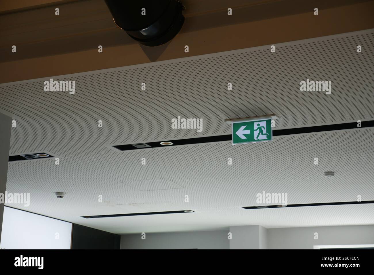 Emergency exit sign with directional arrow in modern building Stock ...