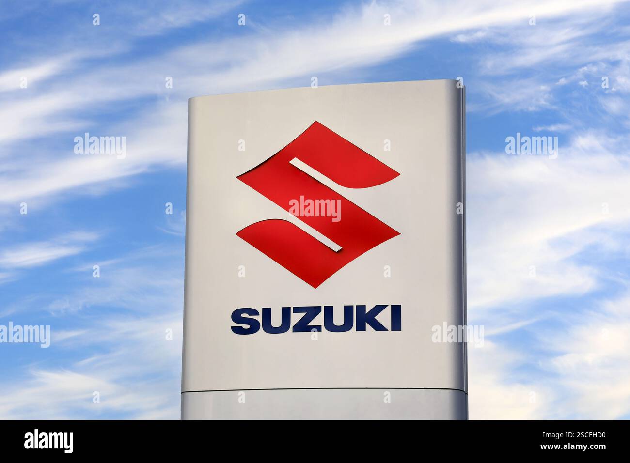 Suzuki logo at the dealership against sky. Suzuki Motor Corporation is ...