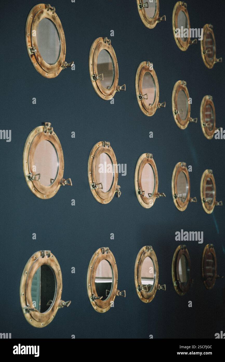 Circular mirrors with metallic frames are arranged in a linear pattern ...