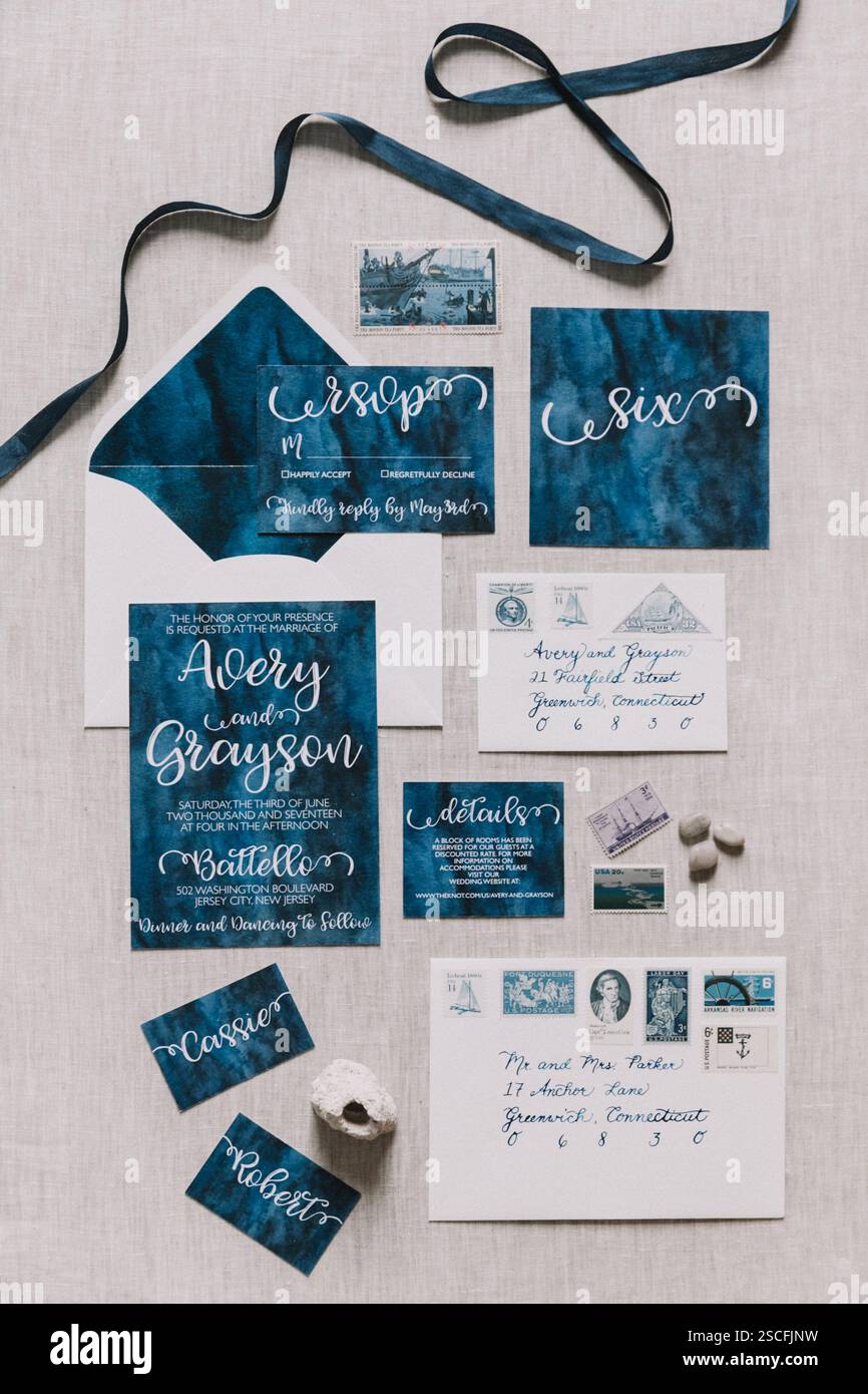 An intricate wedding invitation suite features a deep blue watercolor ...