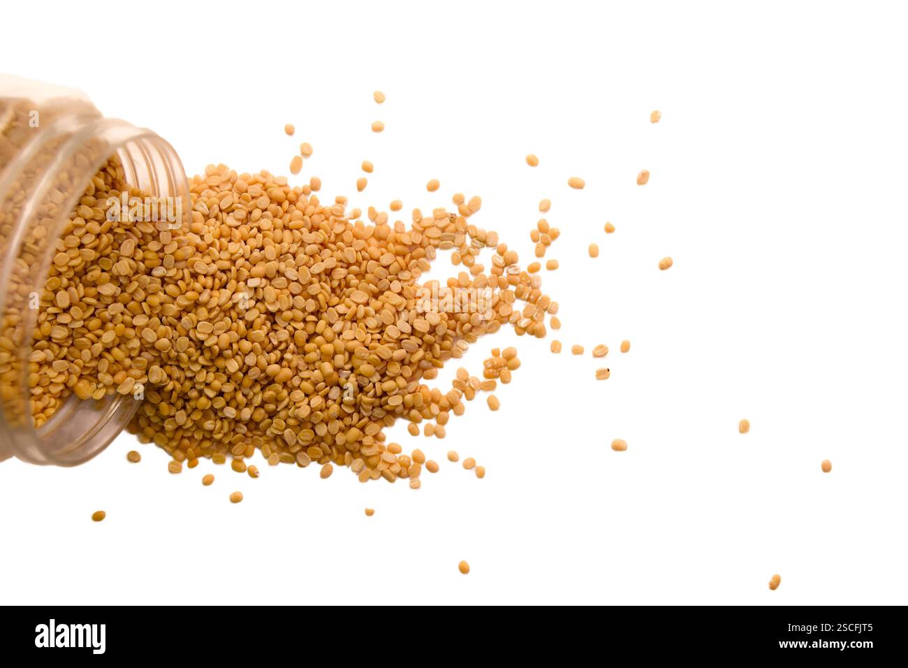 Golden seeds pour from a clear container, creating a vibrant display ...