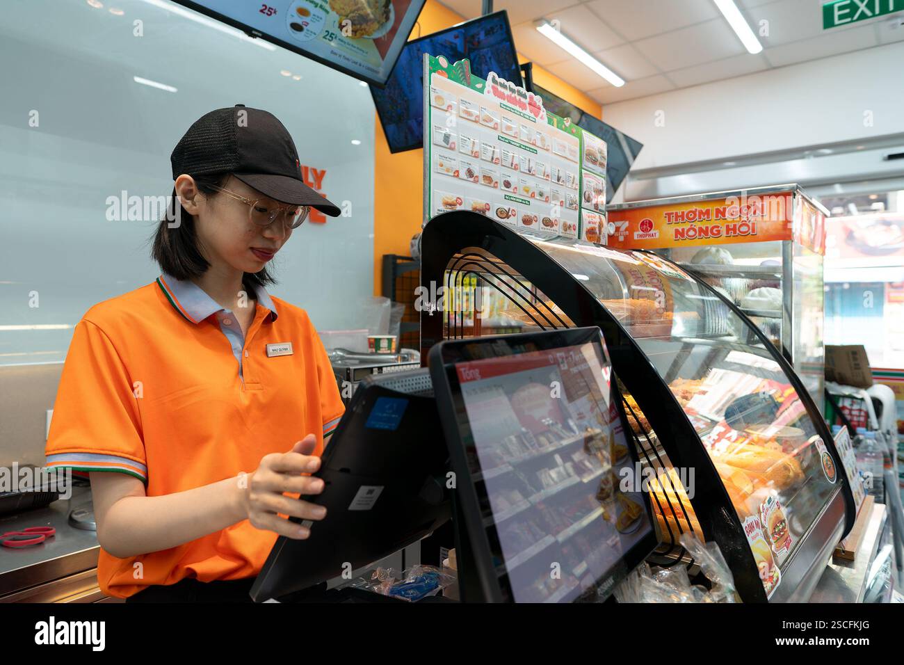 Ho Chi Minh, Vietnam - August 24, 2024: a cashier behind the counter at ...