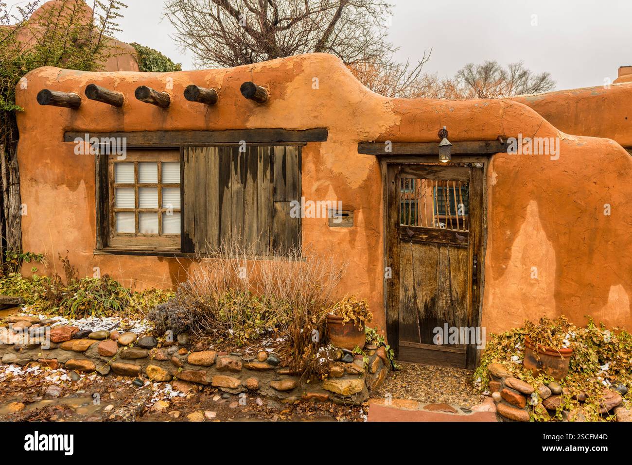 Rustic Adobe House With Wooden Door Stock Photo - Alamy