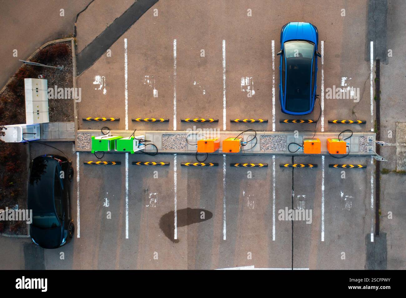 Top view of a blue electric car powers up at an EV charging station in ...