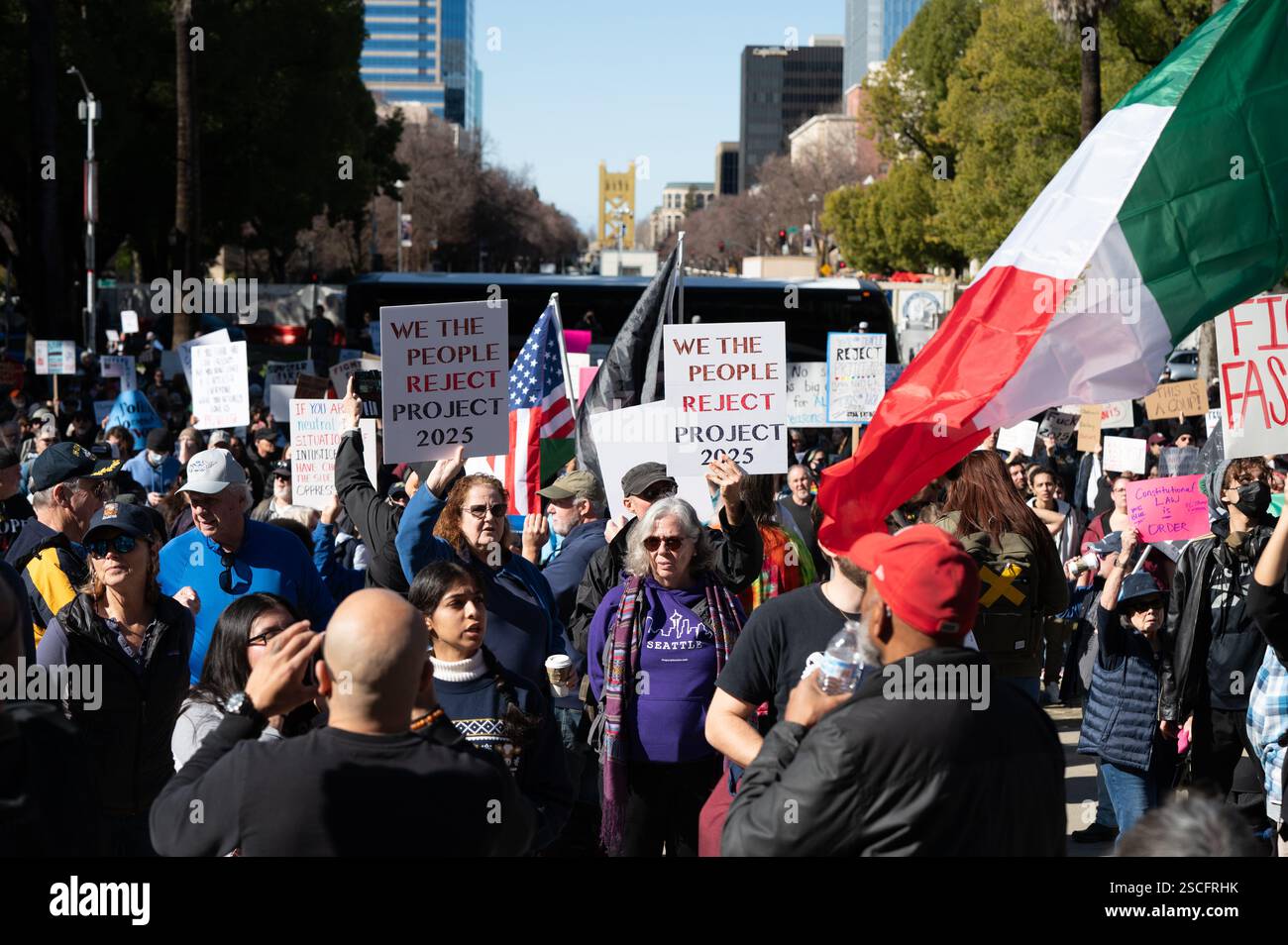 Protesters hold signs about We the People rejecting Project 2025 with ...